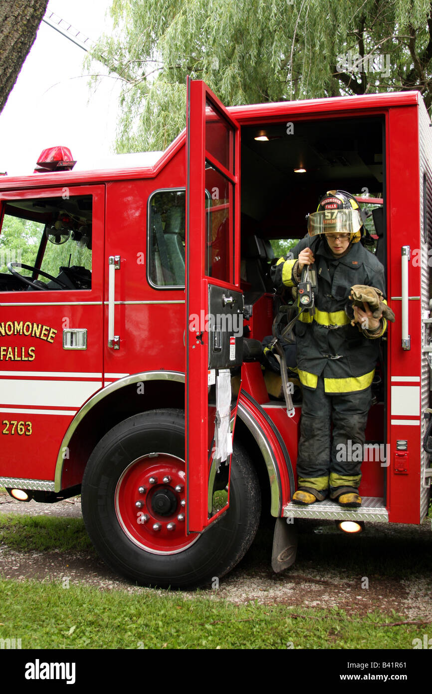 A women firefighter getting a air pack from the fire engine at a ...