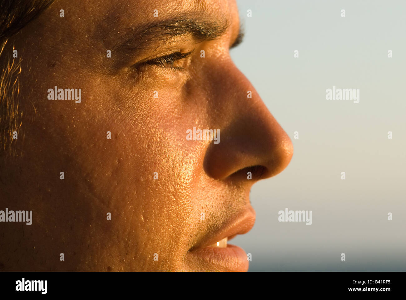 man on the beach facing the sunset Stock Photo - Alamy