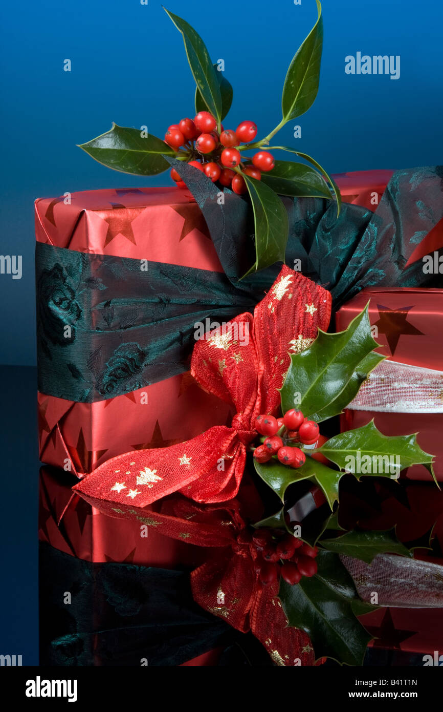 Christmas presents decorated with fresh holly twigs Stock Photo - Alamy
