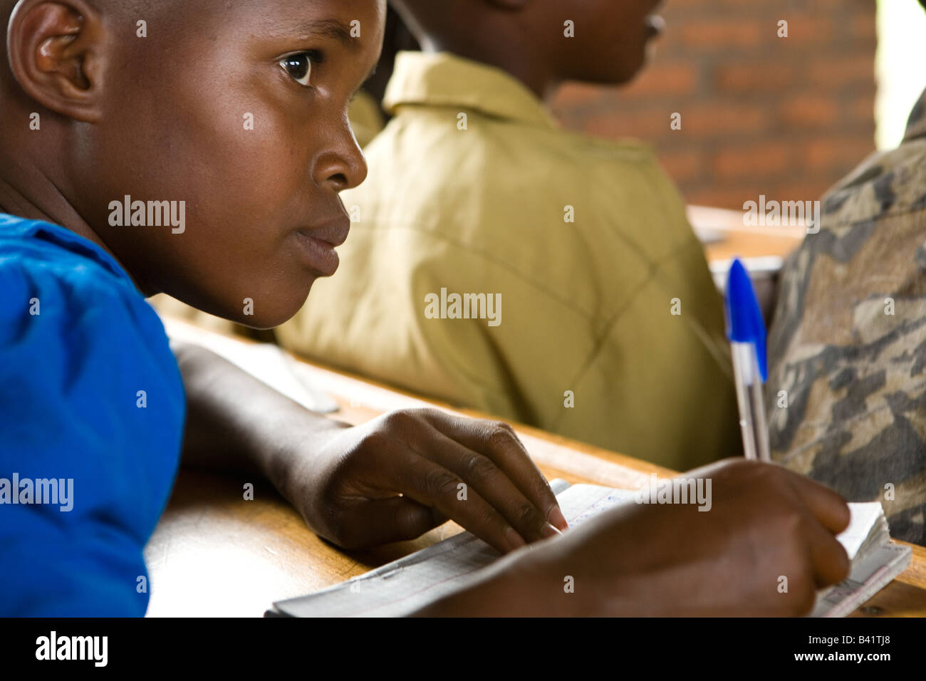 A young Rwandan girl does classwork at her desk Stock Photo - Alamy