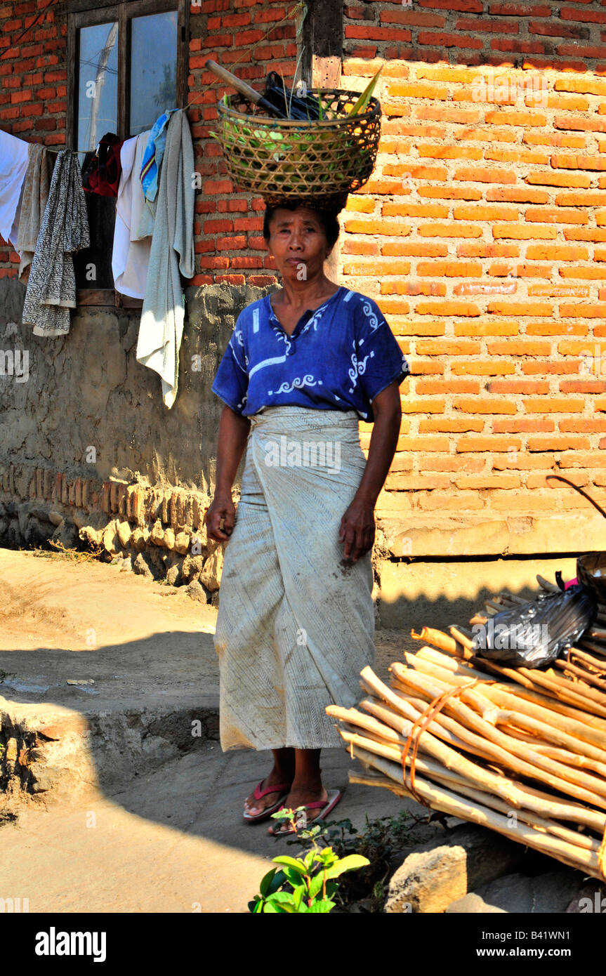bali aga village life, lady street worker carrying tools on her head ...