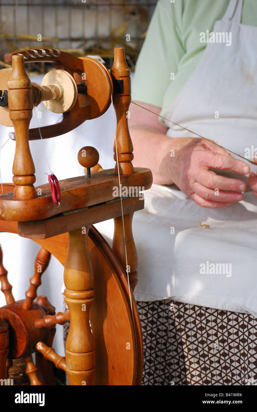 Lady sitting using the Spinning wheel Stock Photo - Alamy