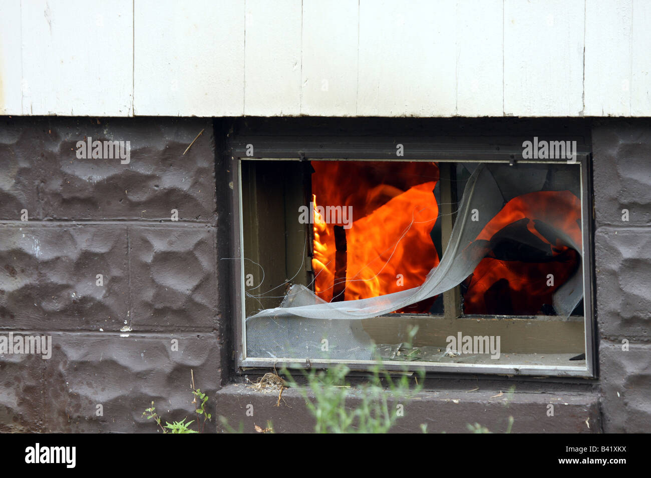 Flames showing in the basement window of a basement fire of a ...