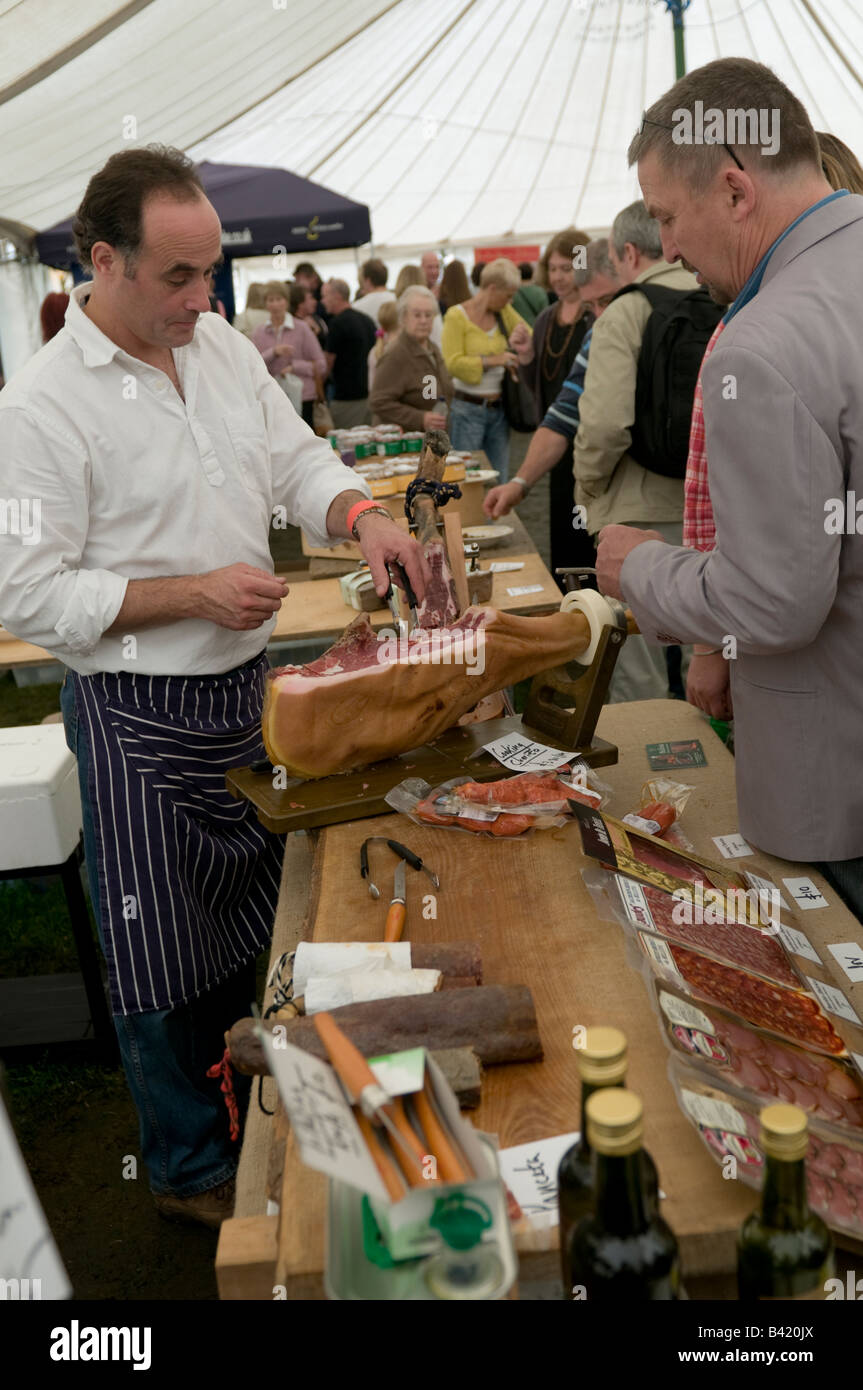 Stallholder carving cured Iberian serrano ham for customer at the Food ...
