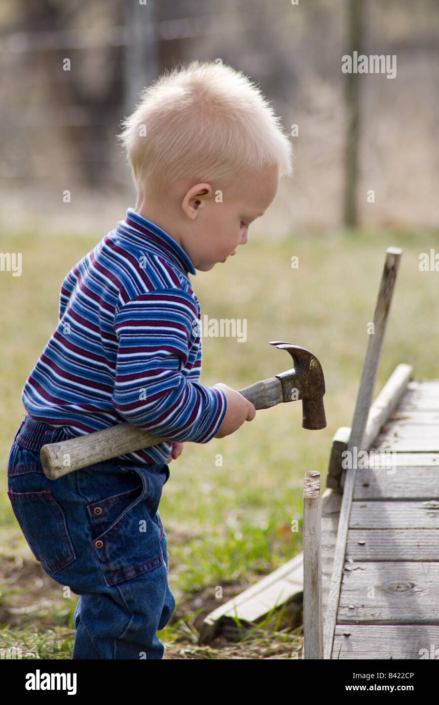 Young boy playing with hammer Stock Photo - Alamy