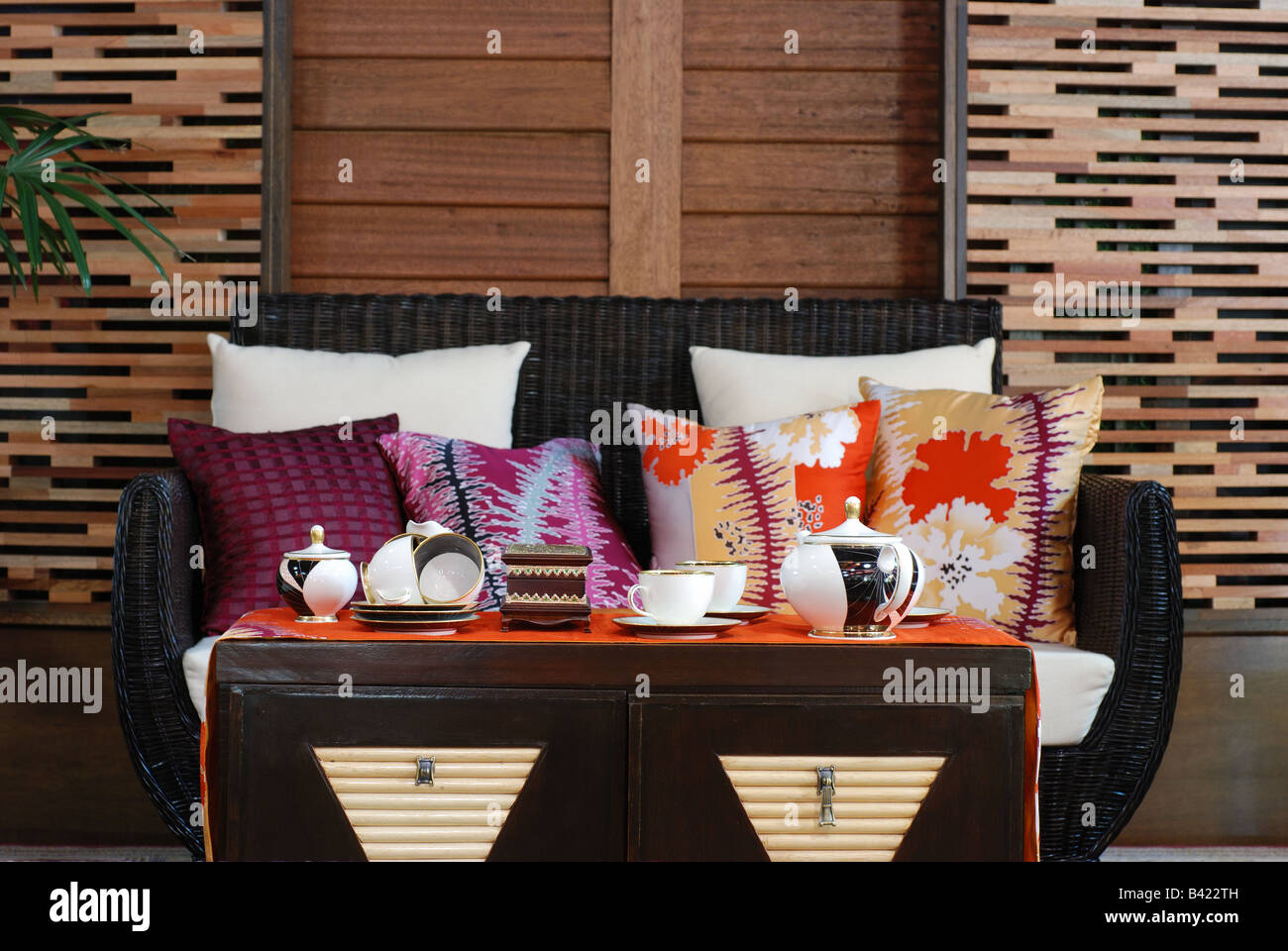 Rattan sofa with batik cloth covered pillows Stock Photo - Alamy