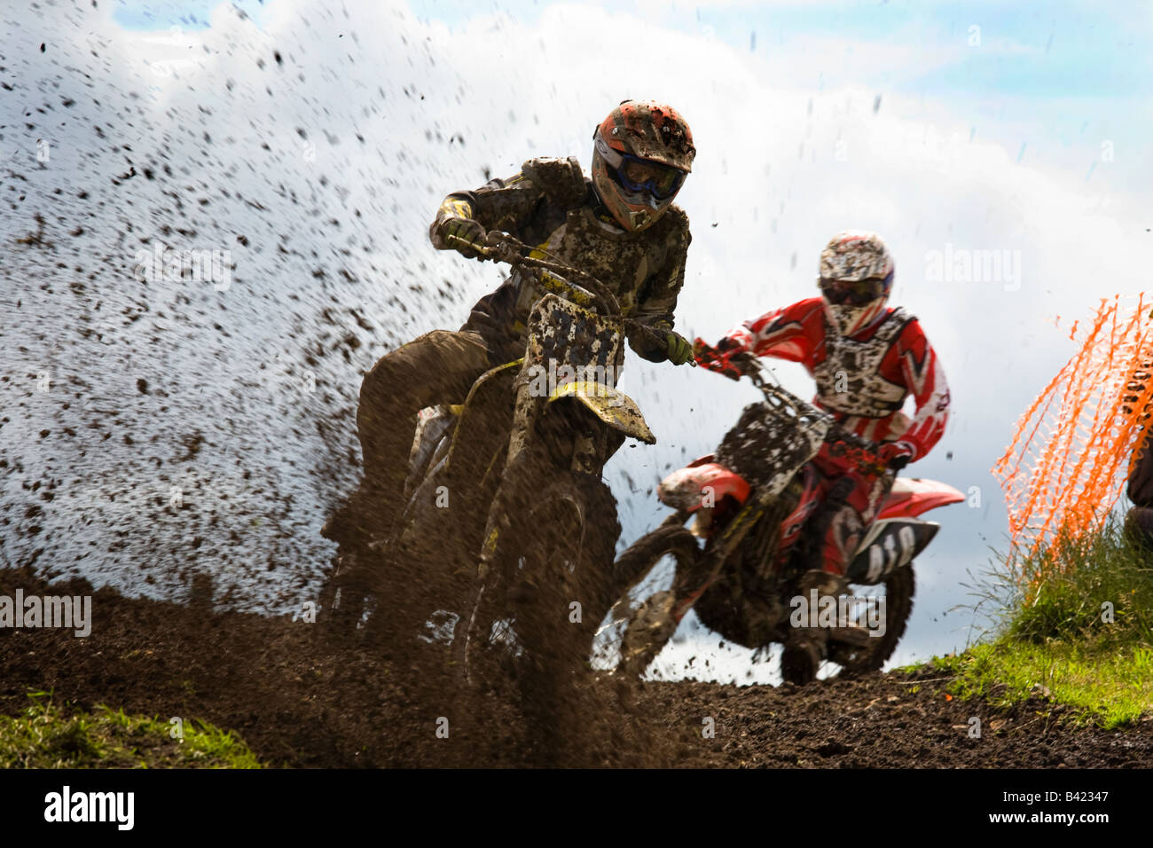 motocross scrambling with the bikes and riders coming over a hill to ...