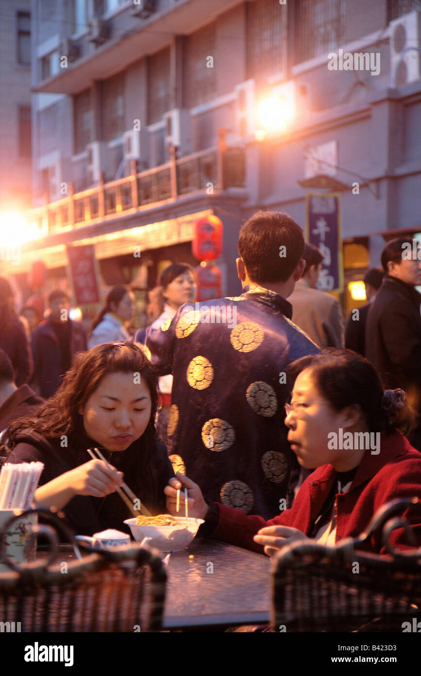 Two Chinese women eating at a street restaurant, Beijing, China Stock ...