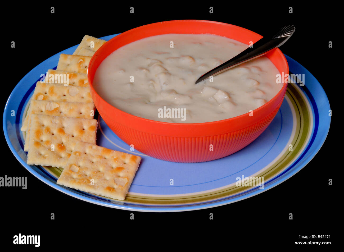 A steaming bowl of clam chowder with crackers isolated over black Stock ...