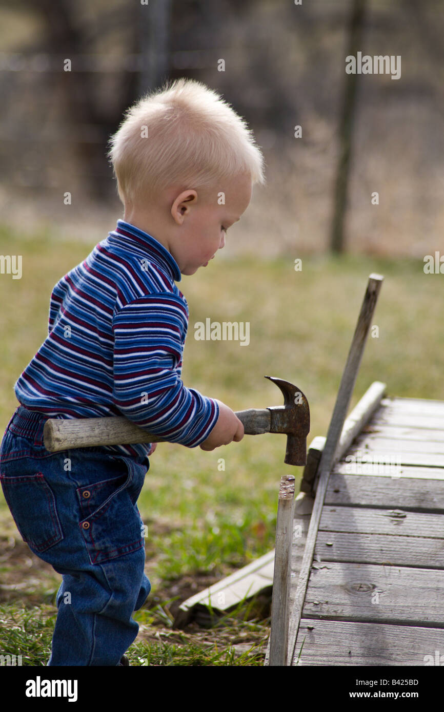 Young boy playing with hammer Stock Photo - Alamy