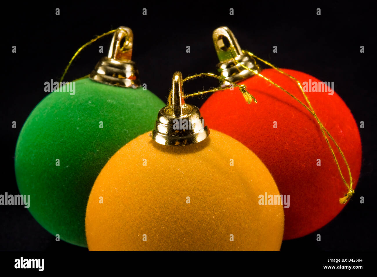A closeup of a group of green yellow and red fuzzy christmas ball ...