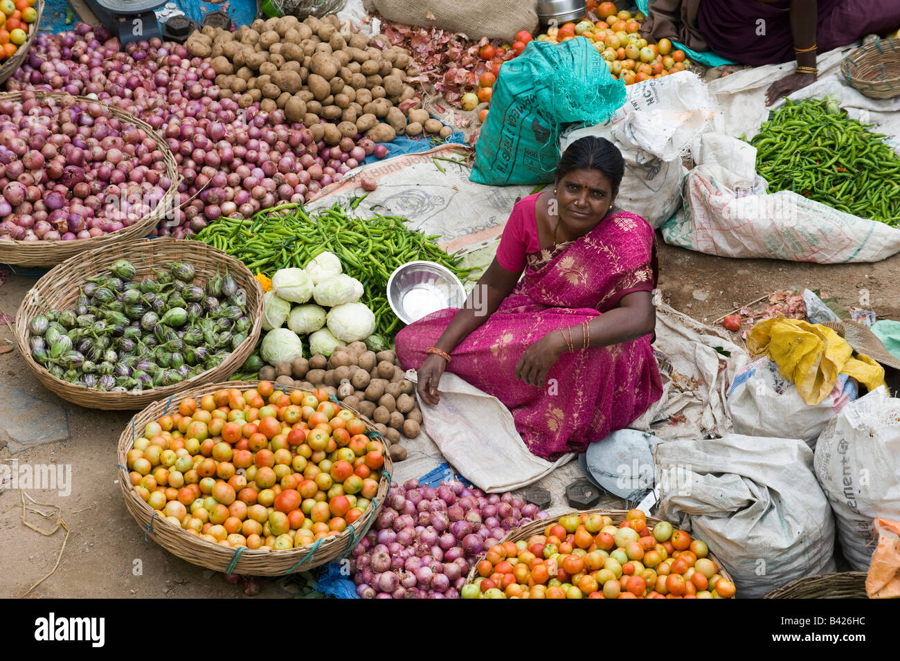 Indian woman selling vegetables at a local india market in the town of Puttaparthi, Andhra ...