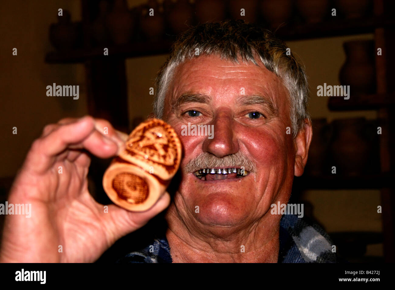 Happy and healthy old man (ceramic artist) smiling and show his work ...