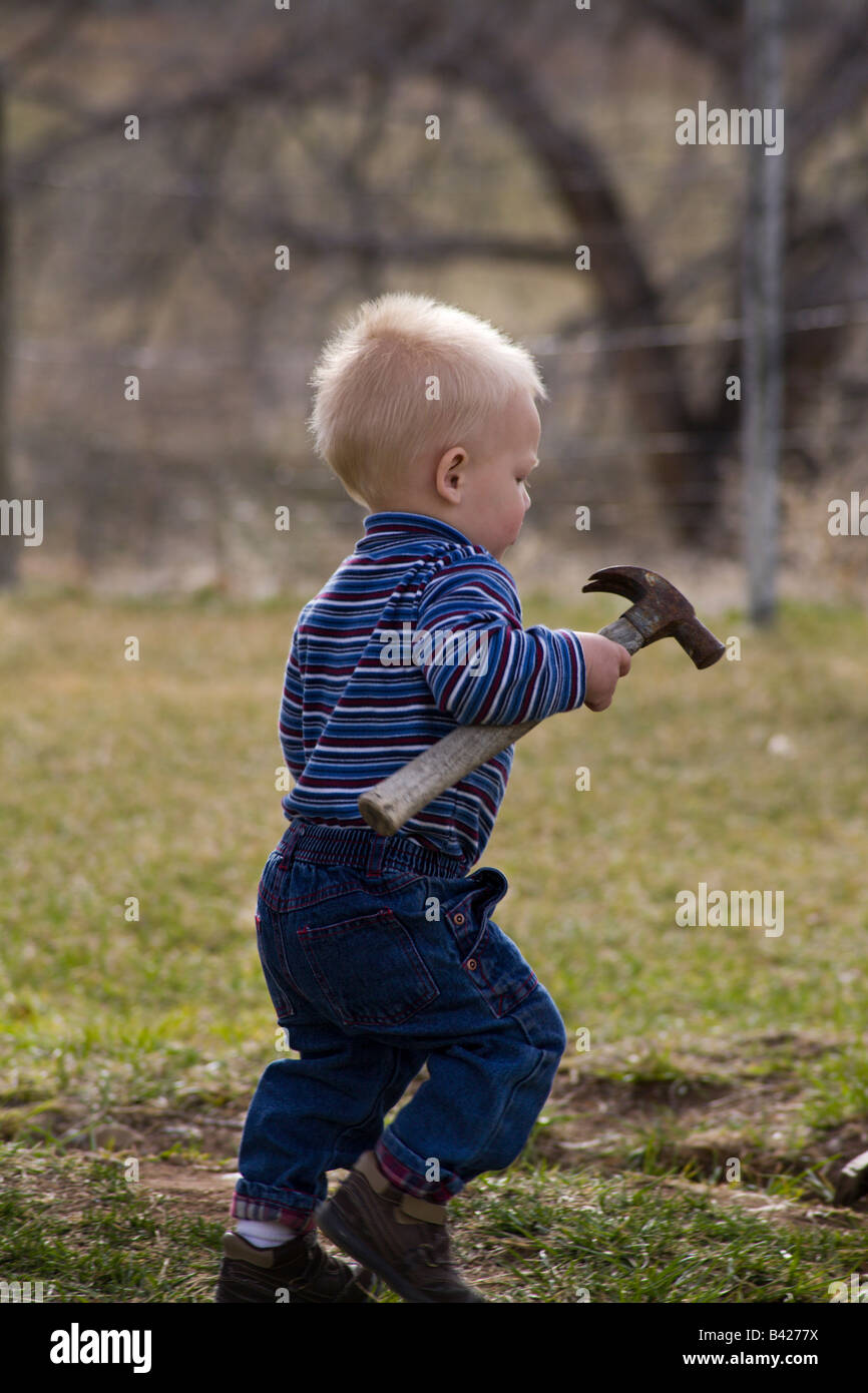 Young boy playing with hammer Stock Photo - Alamy