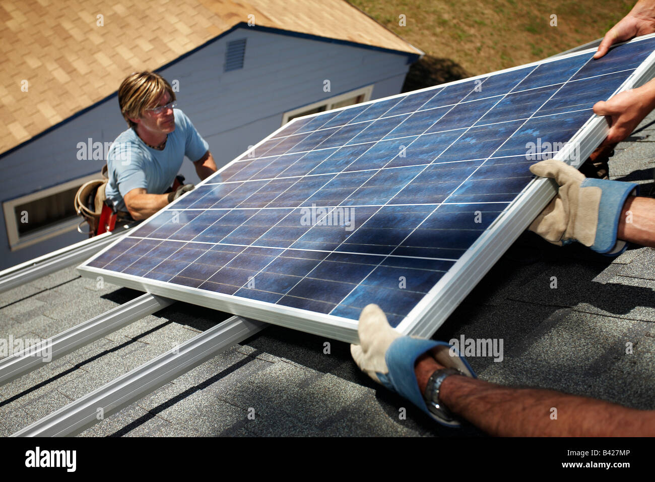 An image of two men installing an array of solar panels on the roof of ...