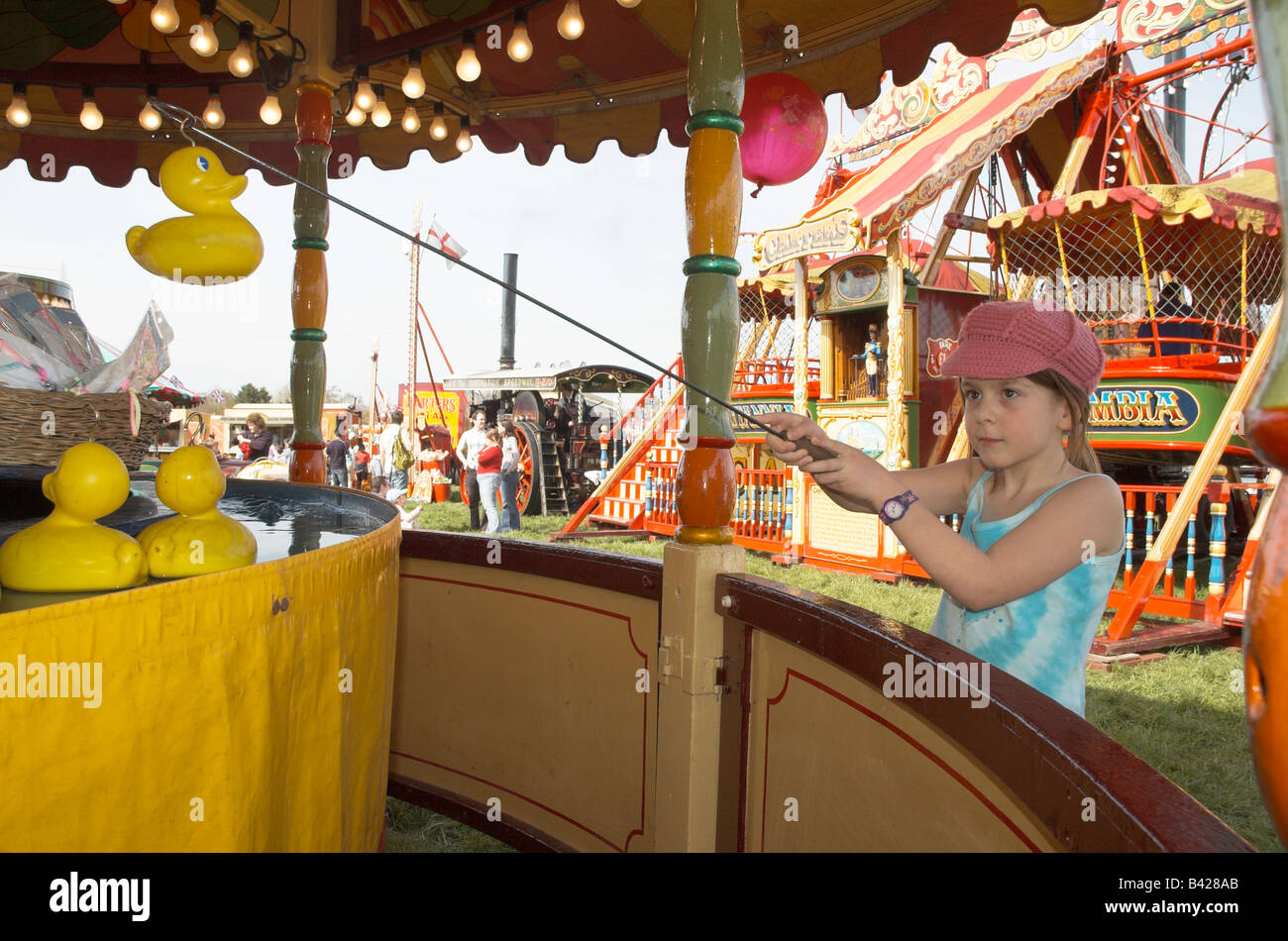 Young girl (7/8) plays hoop a duck at fun fair Stock Photo - Alamy