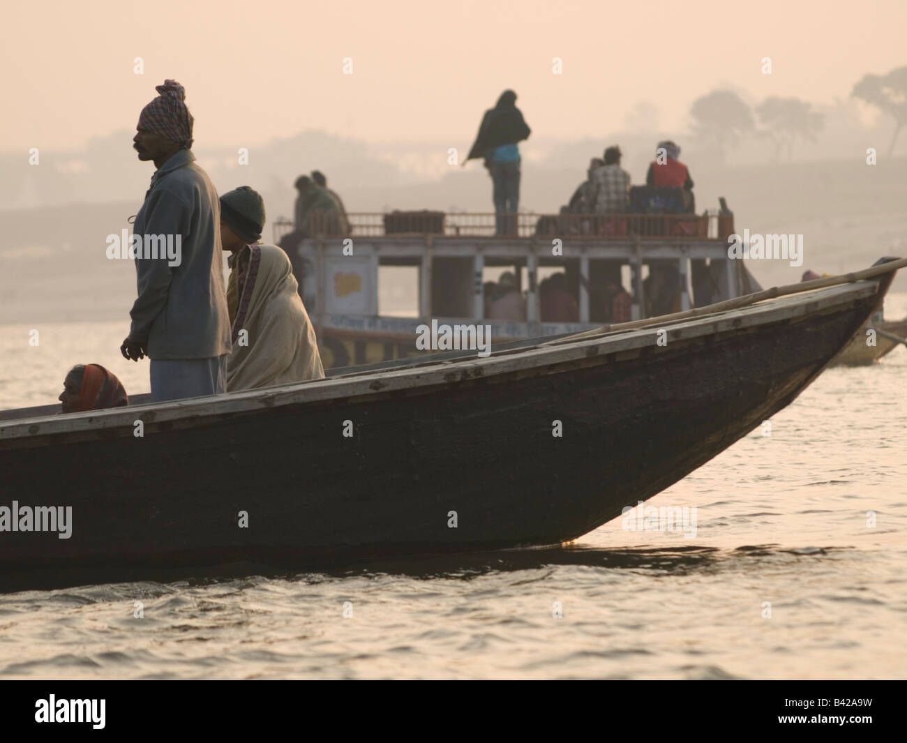 Visitors in a boat watch life along the holy river Ganges an important ...