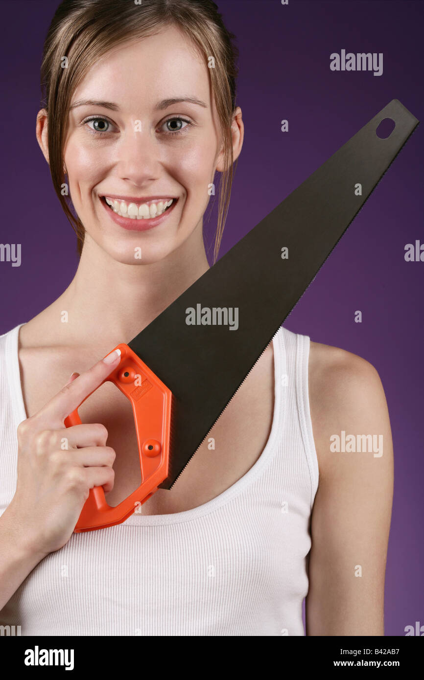 Female model holding a saw Stock Photo - Alamy