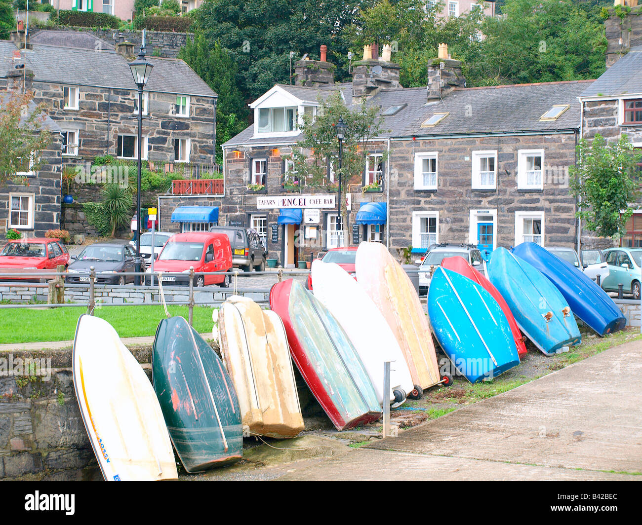 Rowing boats bottom up and gray stone houses and cafe on the harbour at ...