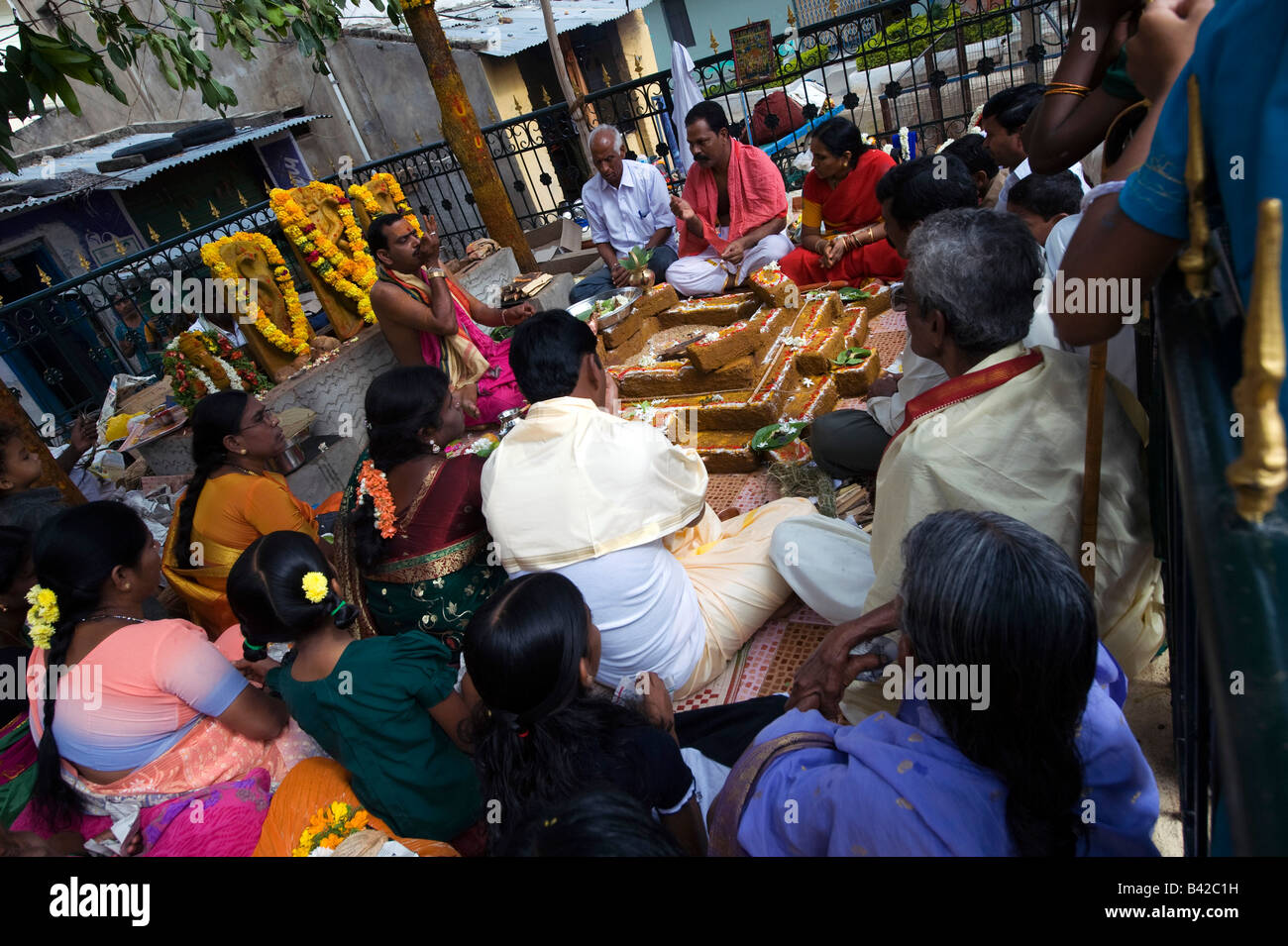 Hindus performing puja at a altar / shrine in the town of Puttaparthi ...