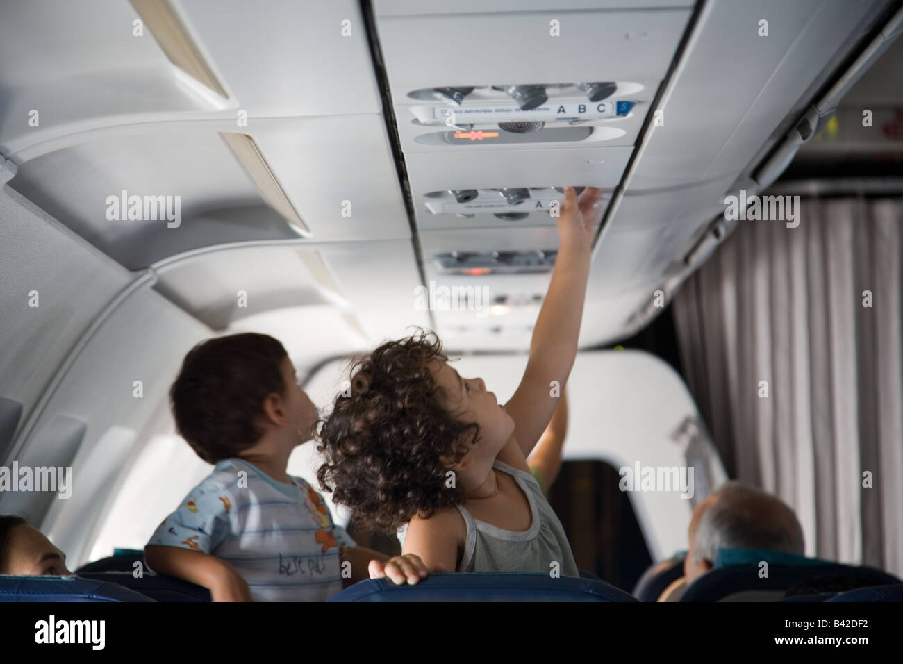Children Playing with Overhead Console Aboard an Aircraft Stock Photo ...