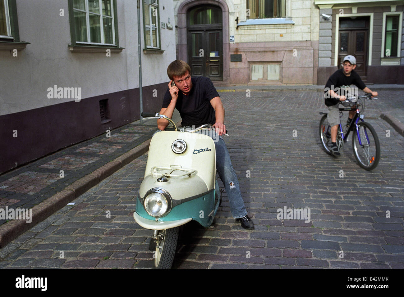 A young man on a scooter, with mobile phone, Riga, Latvia Stock Photo ...