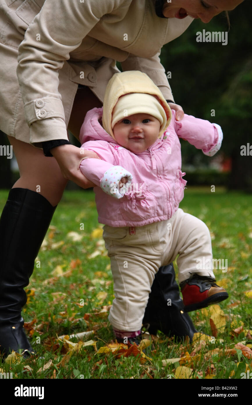 Mother and daughter doing the first steps in a park Stock Photo - Alamy