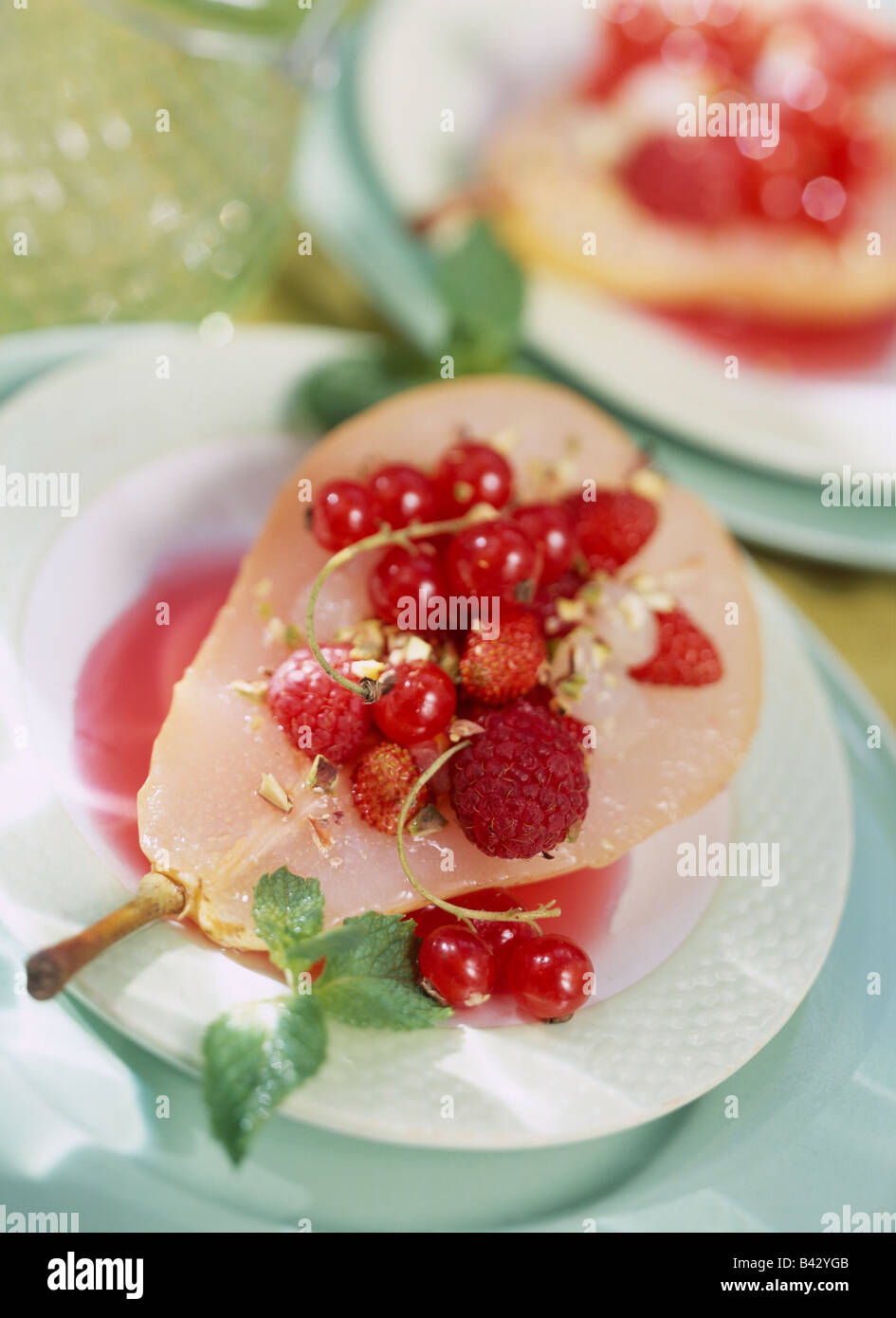 Poached pears stuffed with summer fruit and summer fruit coulis Stock ...