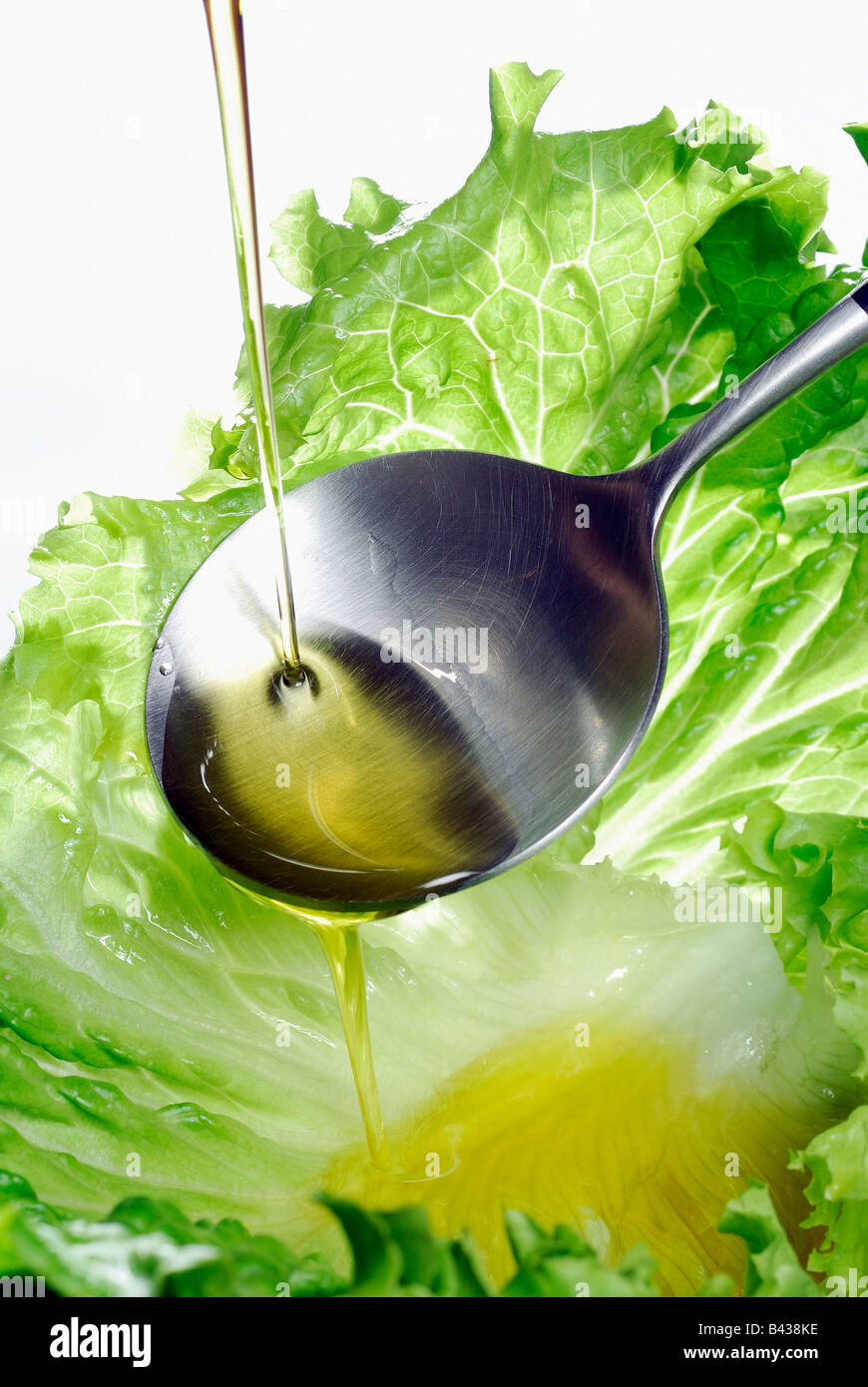 Pouring a drop of olive oil onto a lettuce leaf Stock Photo - Alamy