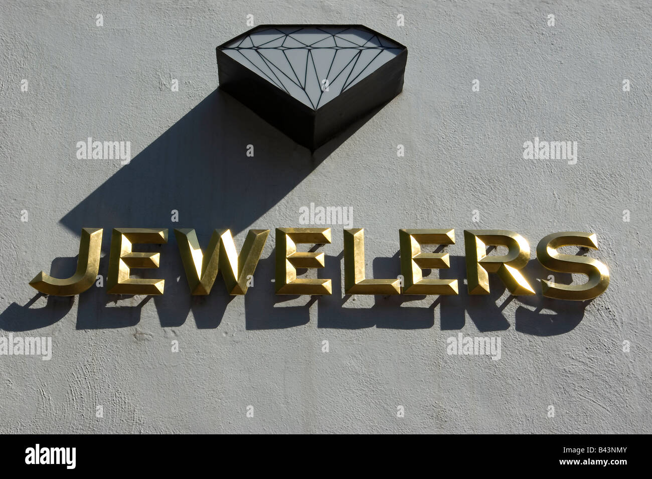 Three dimensional generic jewelers sign on gray cement wall with a ...