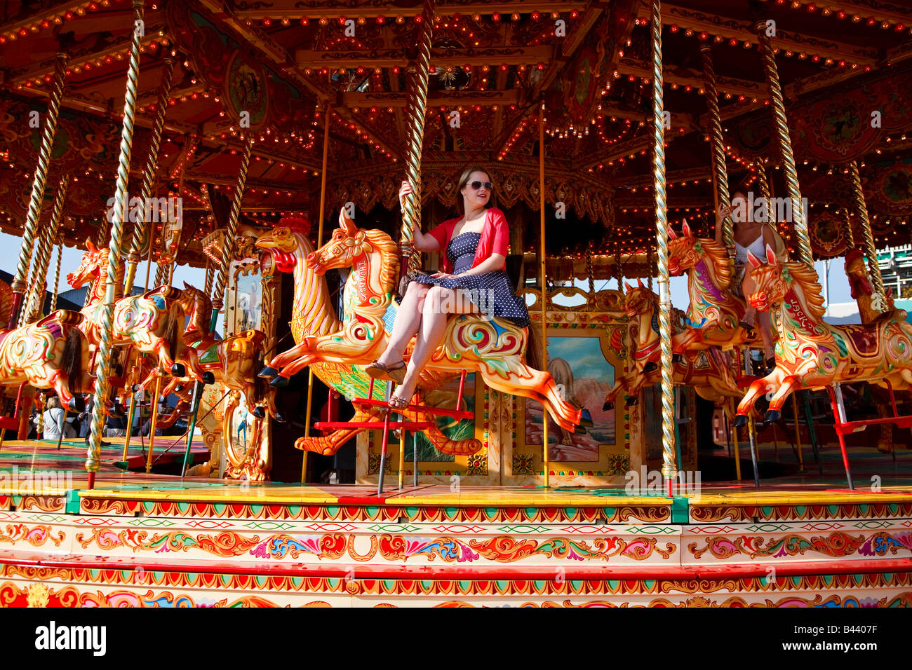 A young woman sitting side saddle on a horse on a carousel, Goodwood ...