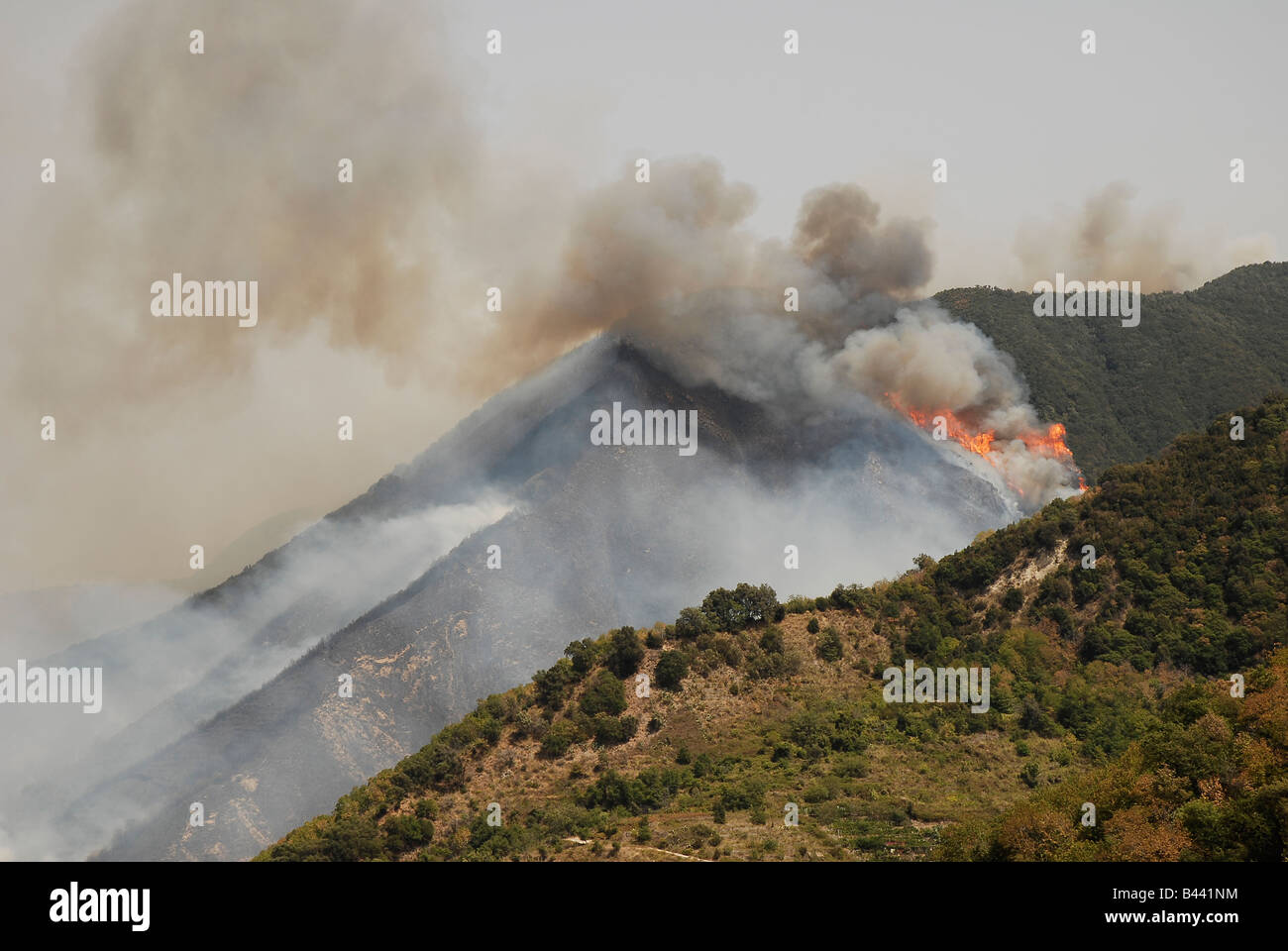 A very big fire is burning over a hill, which is completely surrounded ...
