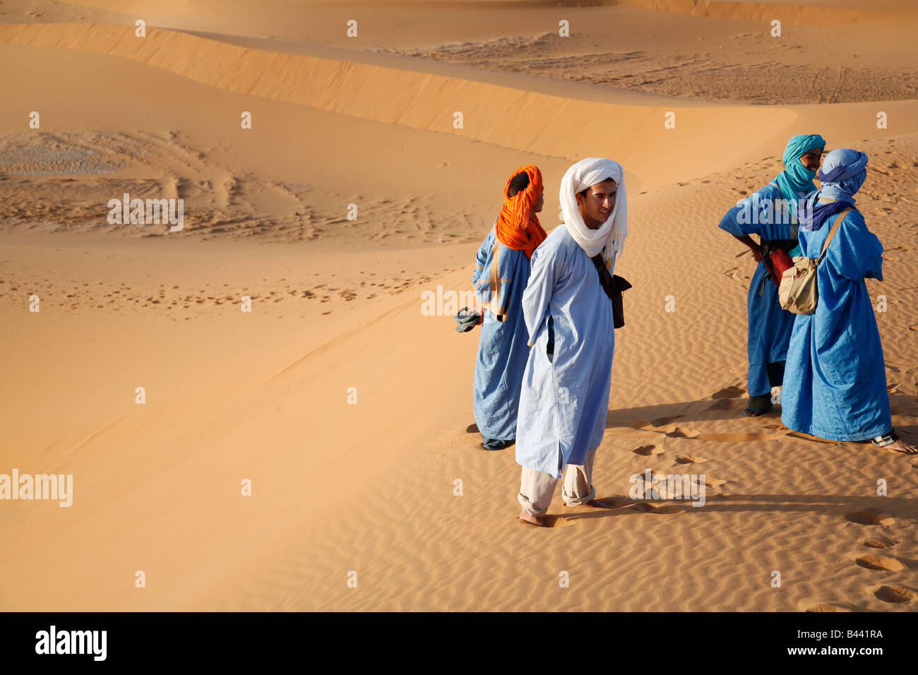 A group of Berber men in traditional blue dress are standing in the ...