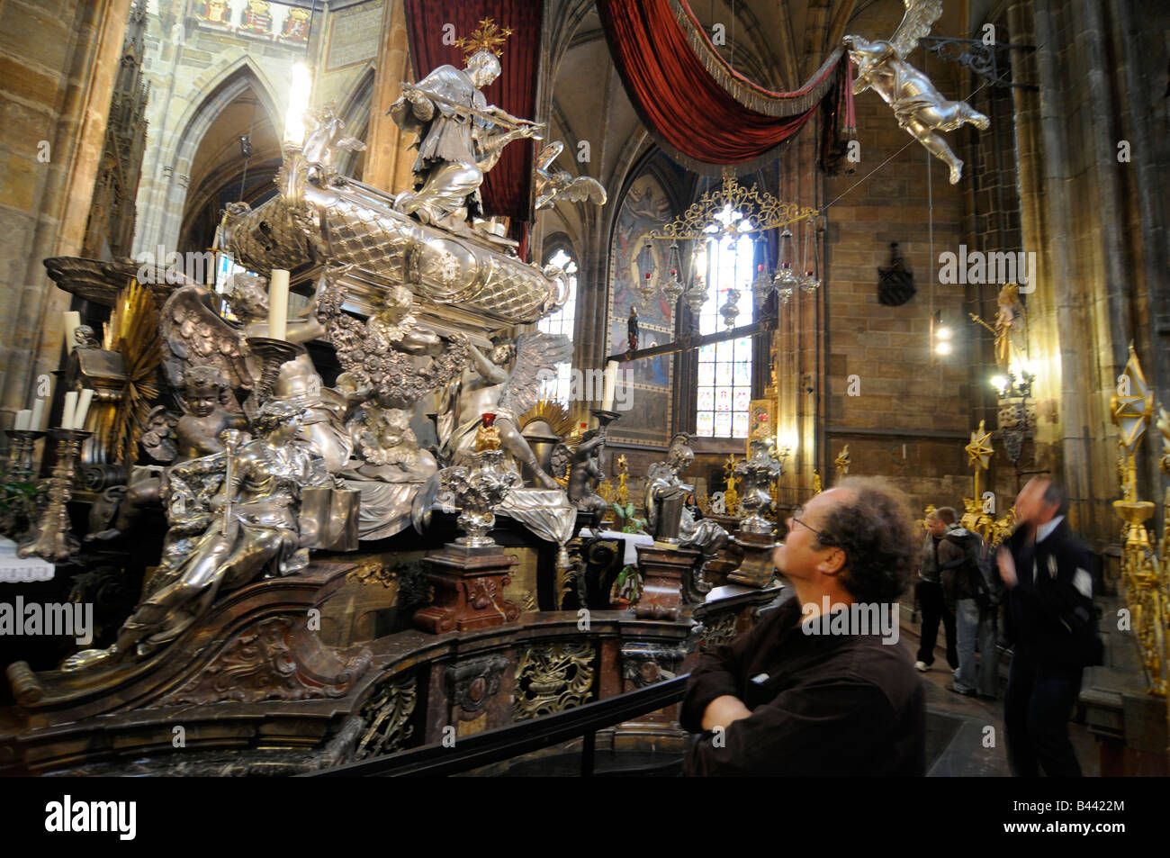 Tourists looking at the richly-decorated silver tomb of St John ...