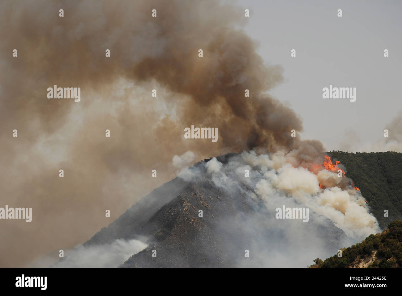 A very big fire is burning over a hill, which is completely surrounded ...