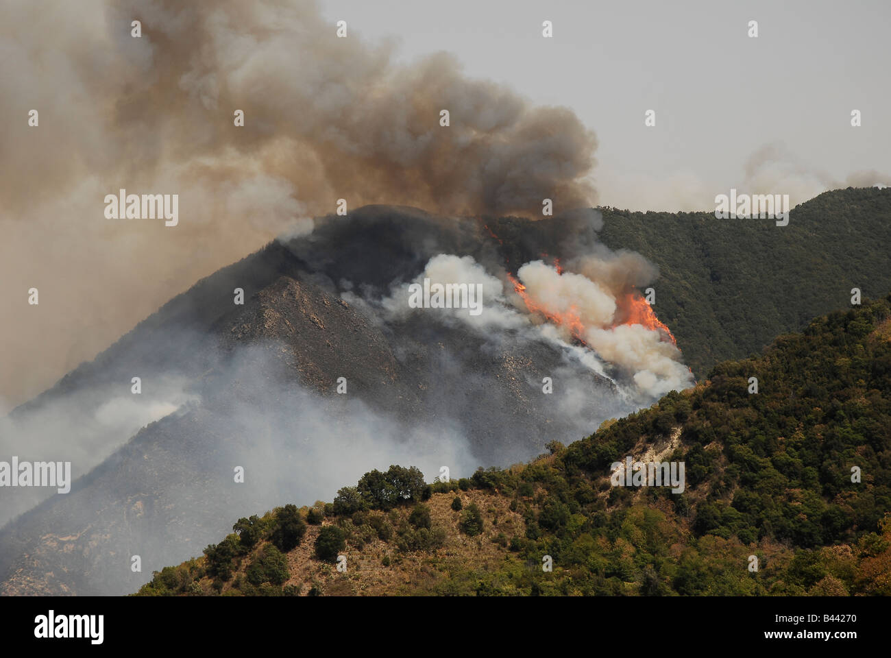 A very big fire is burning over a hill, which is completely surrounded ...