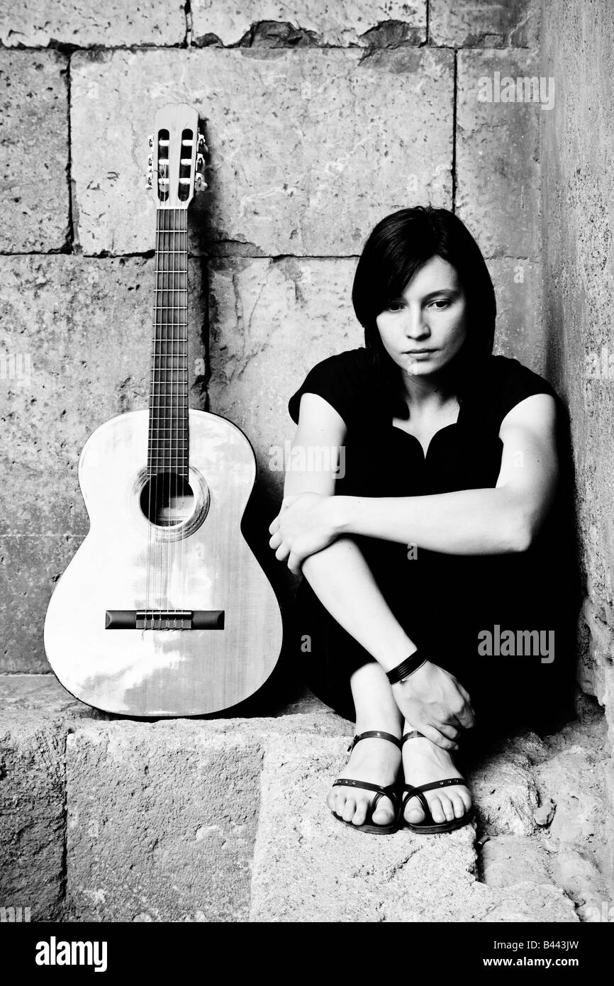 Young sad guitarist staring at camera Stock Photo - Alamy