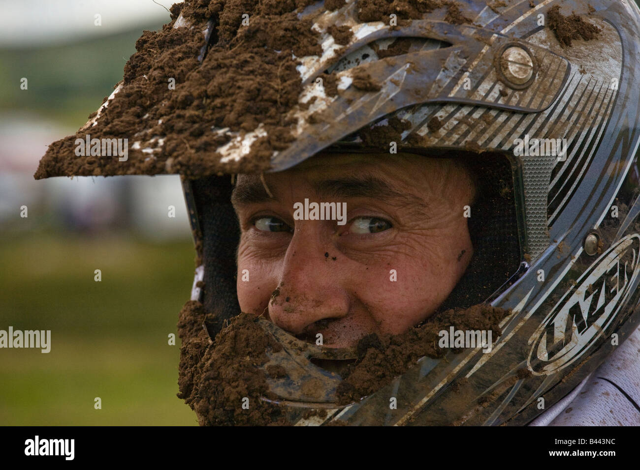 Man with crash helmet covered with mud involved in motocross racing ...