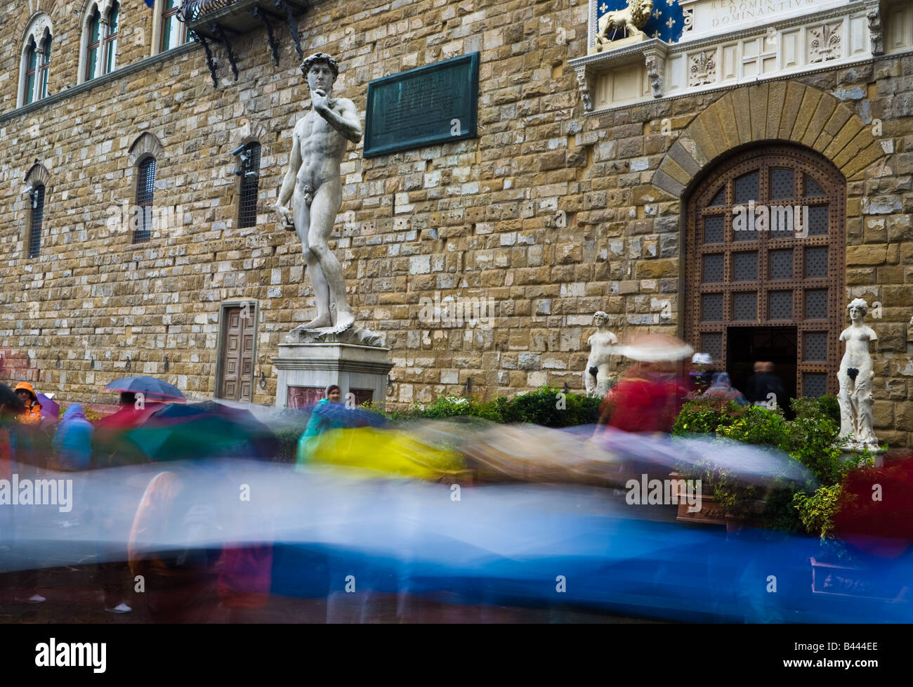 Tourists with umbrellas milling around the statue of David in Piazza ...