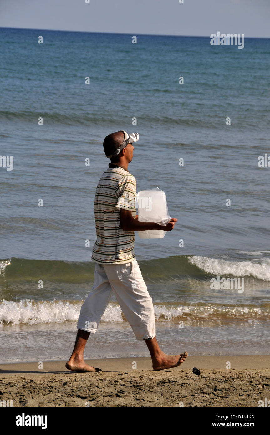 man walking on the beach carrying an ice cube Stock Photo - Alamy