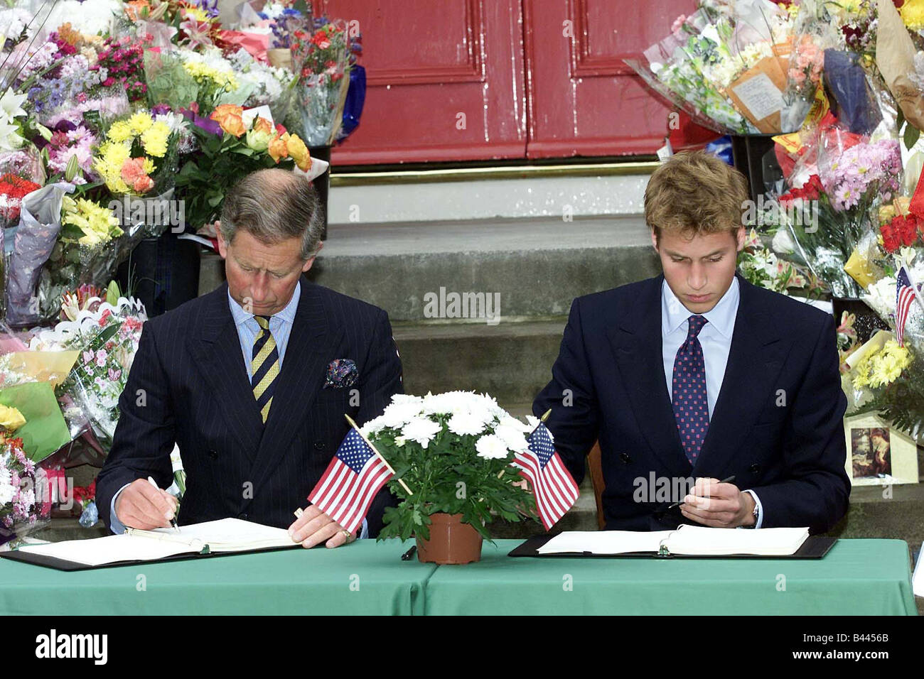 Prince Charles with by his eldest son Prince William signing a book of ...