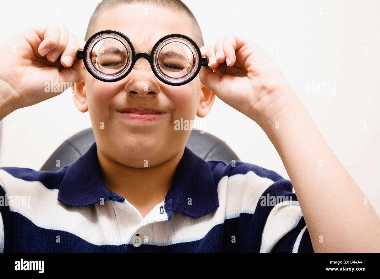 Asian boy taking off eye glasses Stock Photo - Alamy