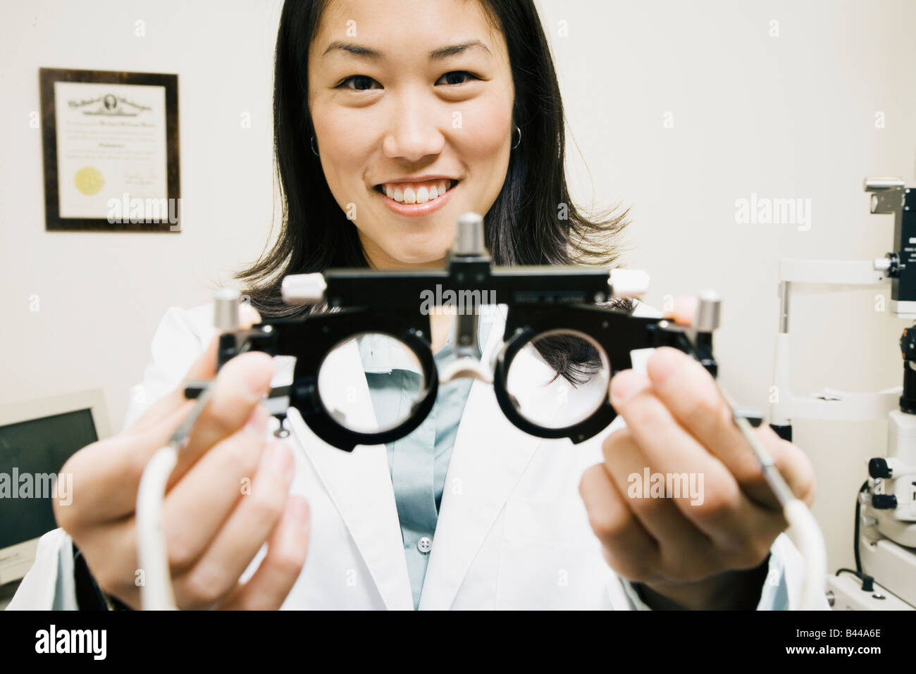 Asian female optometrist holding equipment Stock Photo - Alamy