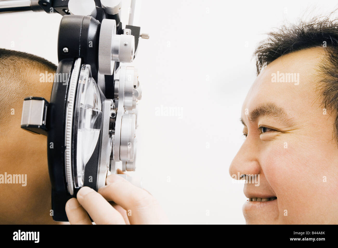 Asian male optometrist examining patient Stock Photo - Alamy