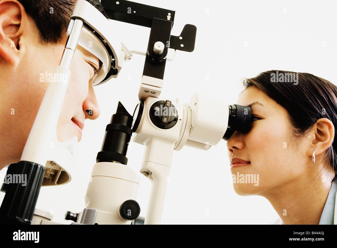 Asian female optometrist examining patient Stock Photo - Alamy