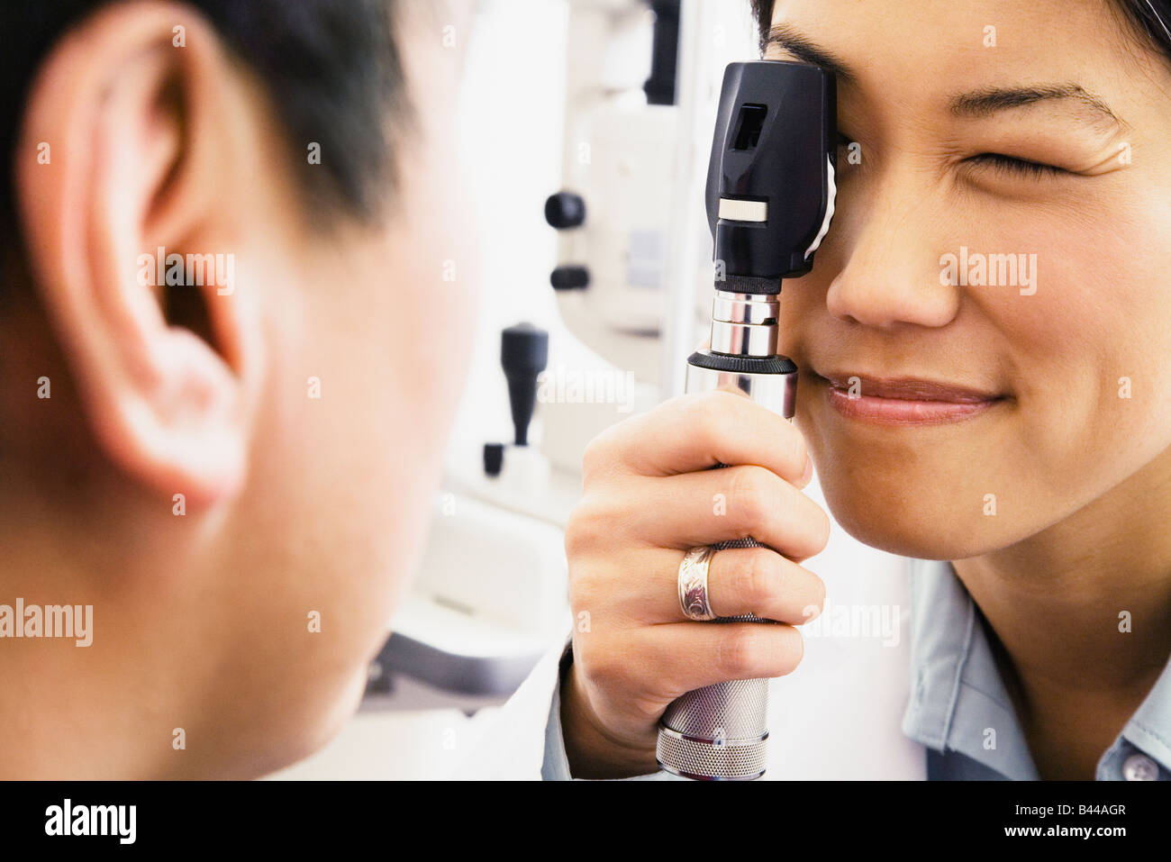 Asian female optometrist examining patient Stock Photo - Alamy