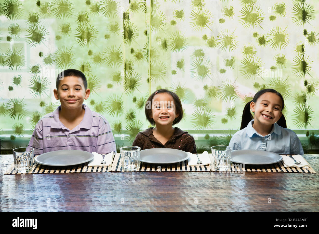 Asian siblings sitting at dinner table Stock Photo - Alamy