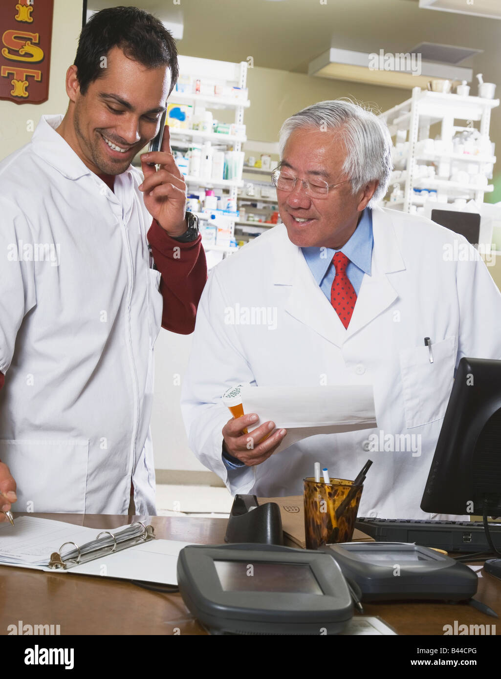 Multi-ethnic pharmacists looking at paperwork Stock Photo - Alamy