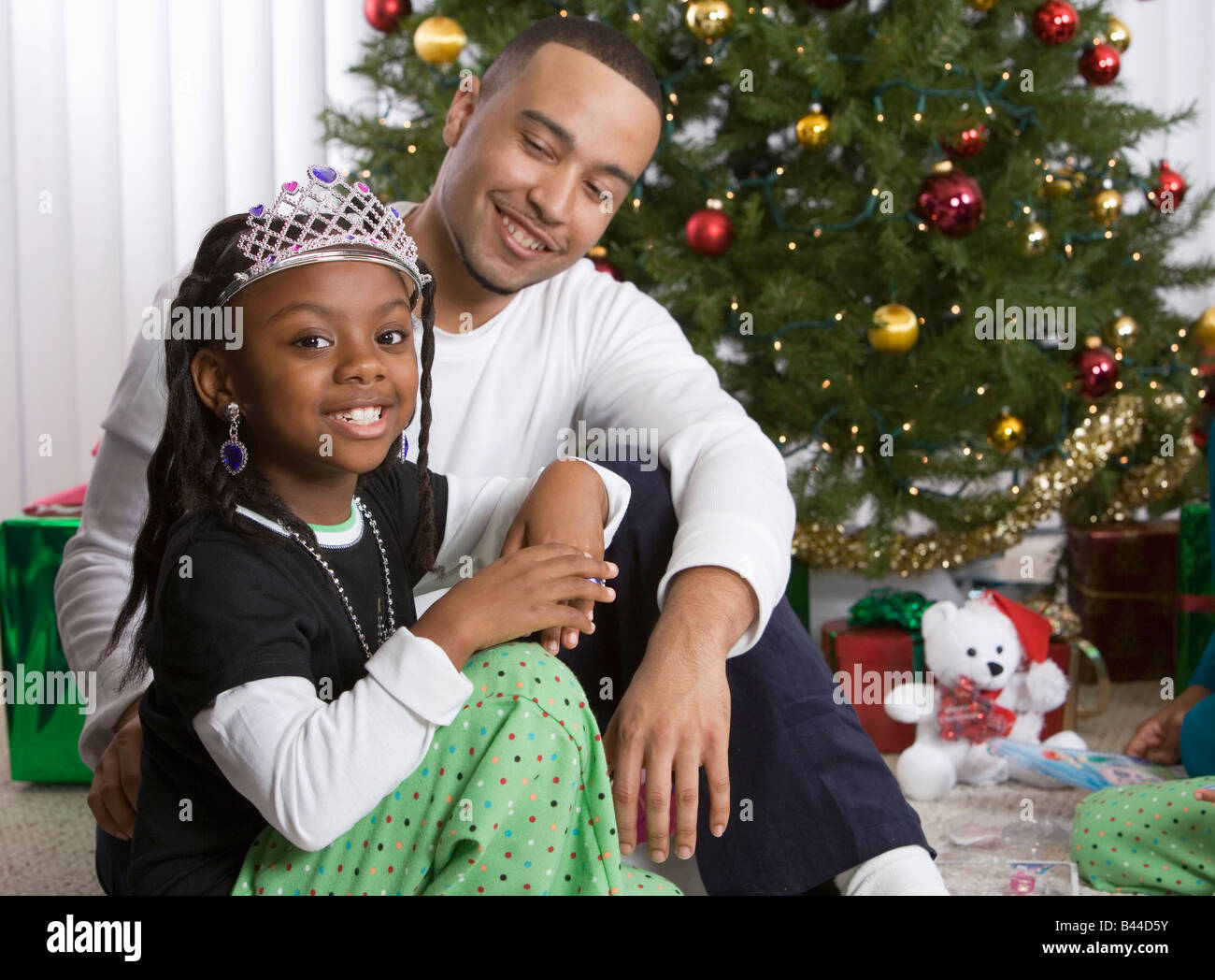African father and daughter in front of Christmas tree Stock Photo - Alamy