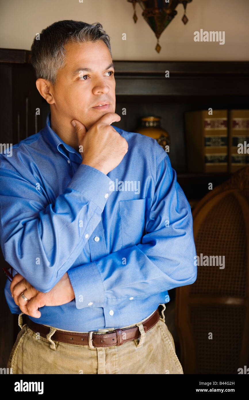 Hispanic man thinking with hand on chin Stock Photo - Alamy